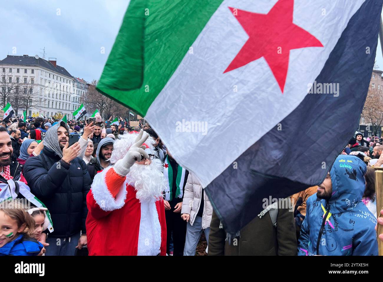 People with flag of the Syrian Republic and a man dressed as Santa ...