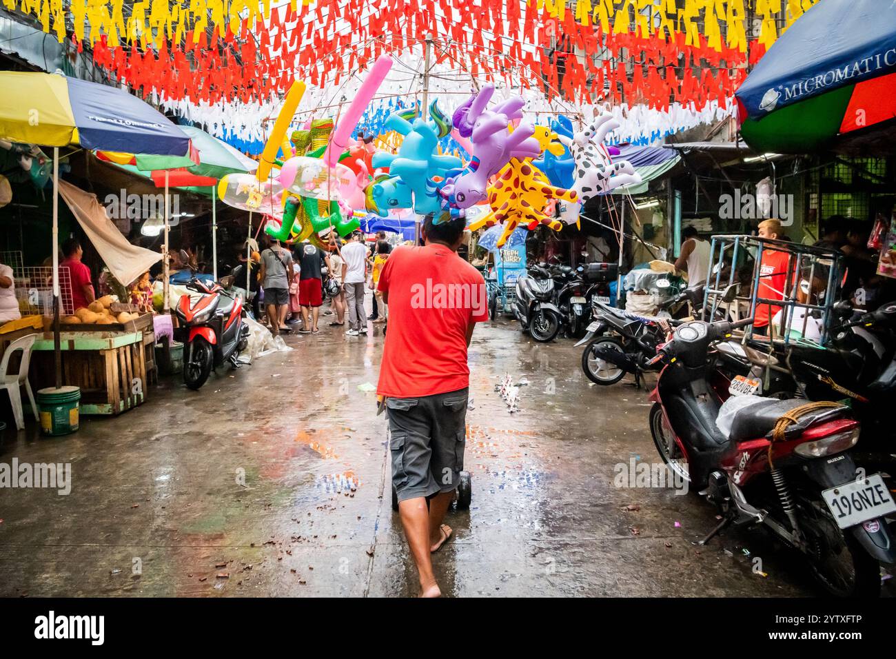 A street balloon vendor makes his way through the crowded streets of ...