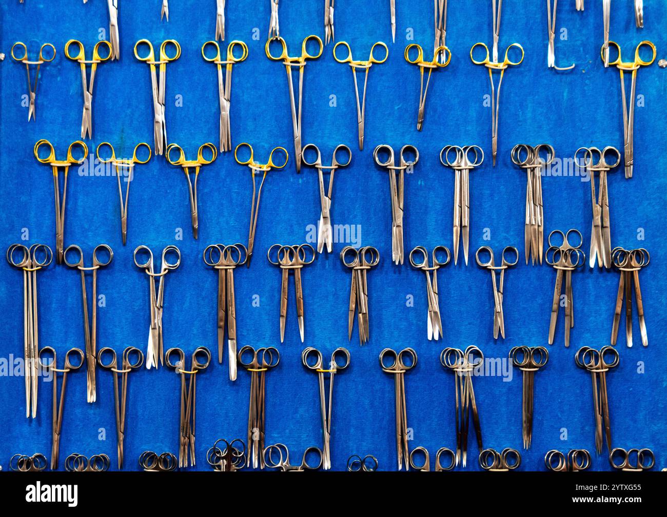 Surgical instruments, medical scissors and various types of clamps hang ...