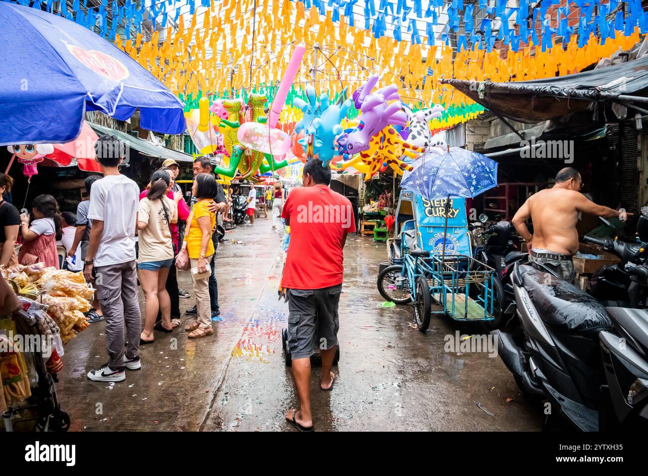 A street balloon vendor makes his way through the crowded streets of ...