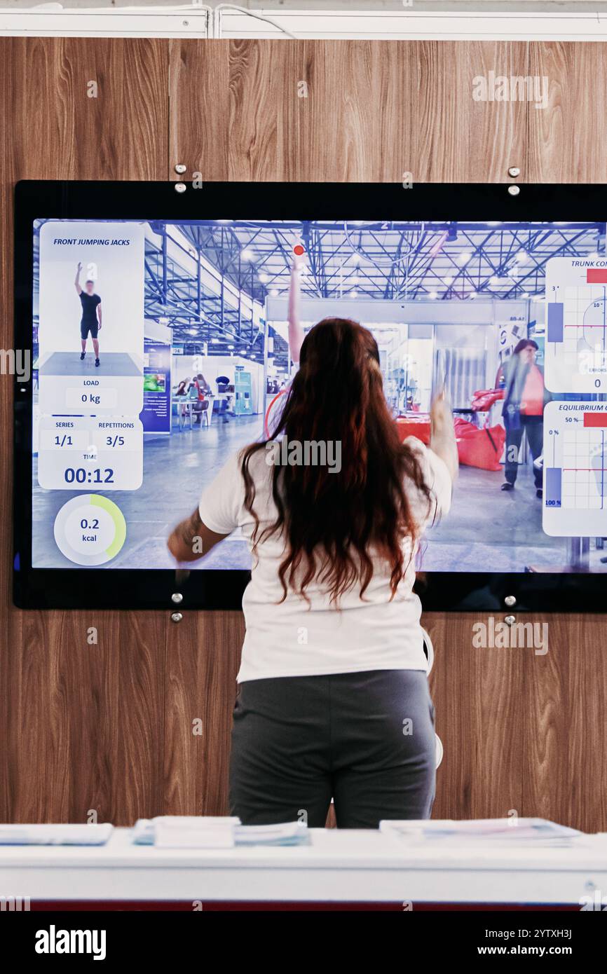 A woman trains using an interactive television system with feedback Stock Photo - Alamy