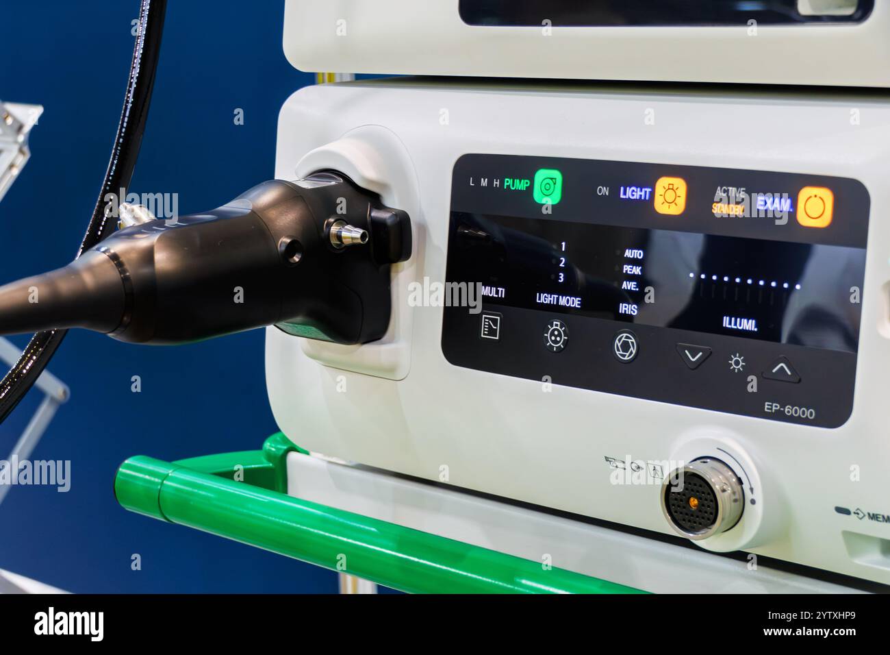 The medical device is connected to a black endoscope or similar device ...