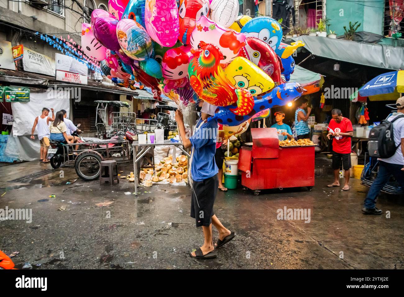 A street balloon vendor makes his way through the crowded streets of ...