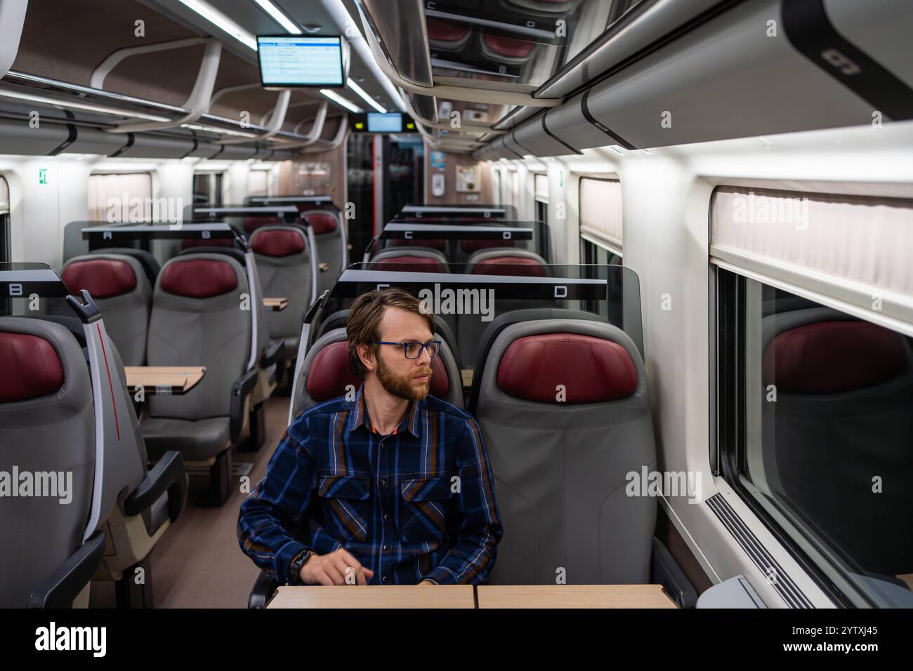 A man rides alone on a train and stares out the window Stock Photo - Alamy