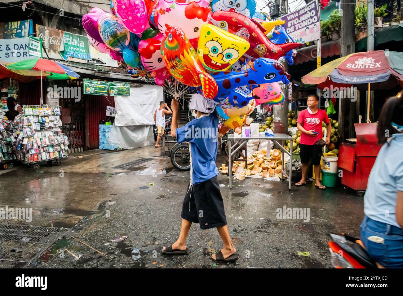 A street balloon vendor makes his way through the crowded streets of ...