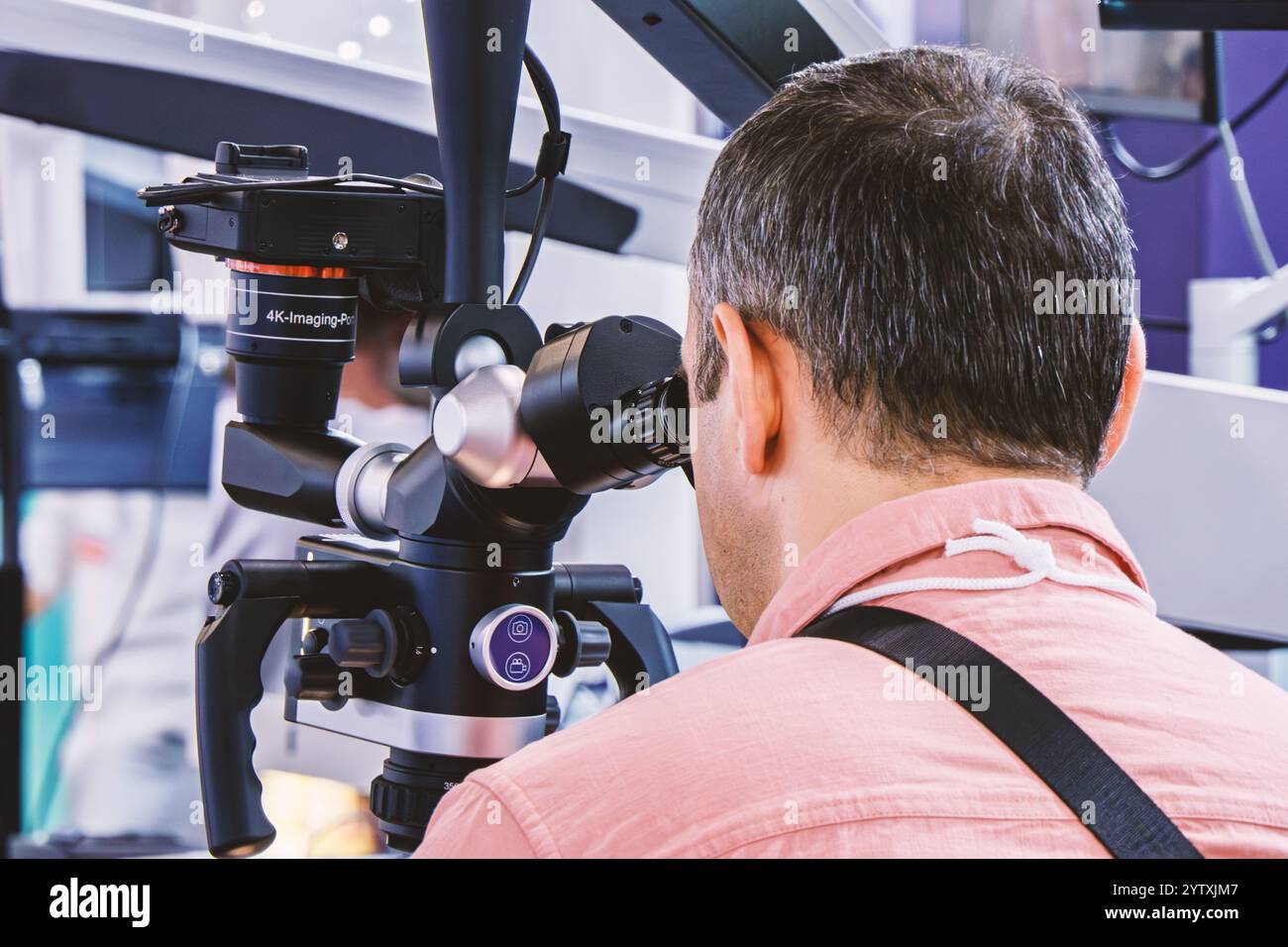 Man looking into a dental microscope Stock Photo - Alamy
