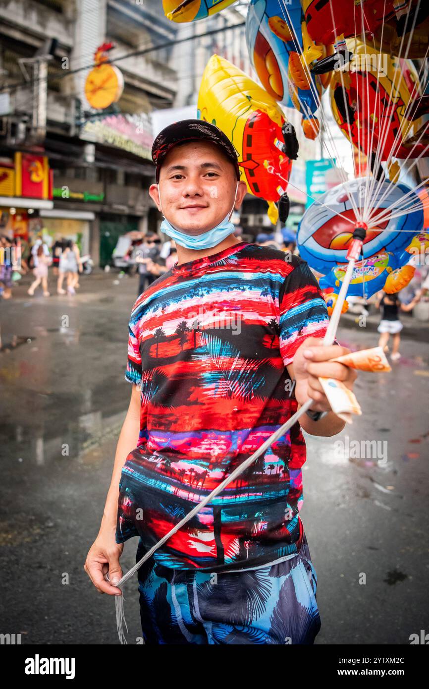 A street balloon vendor makes his way through the streets in the Tondo ...