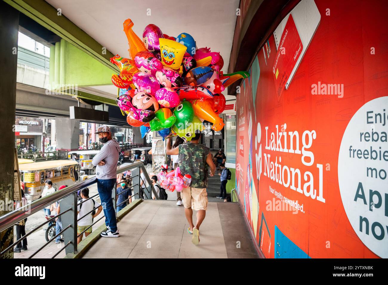 A street balloon vendor makes his way through the streets and walkway ...