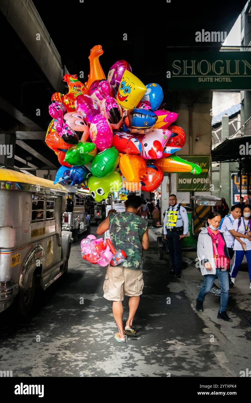 A street balloon vendor makes his way through the streets and walkway ...