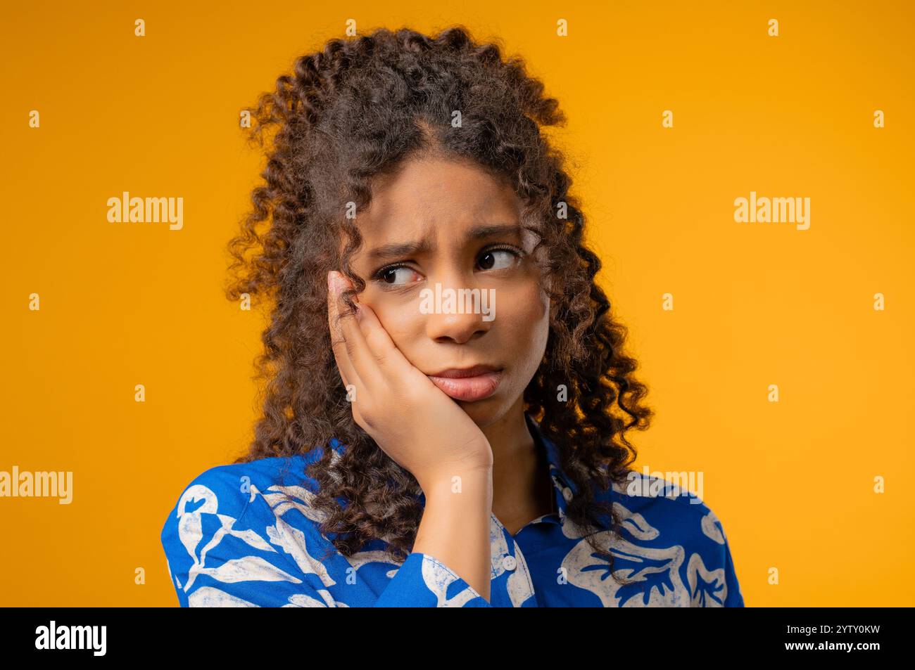 African teenager with tooth pain on yellow background. Toothache ...
