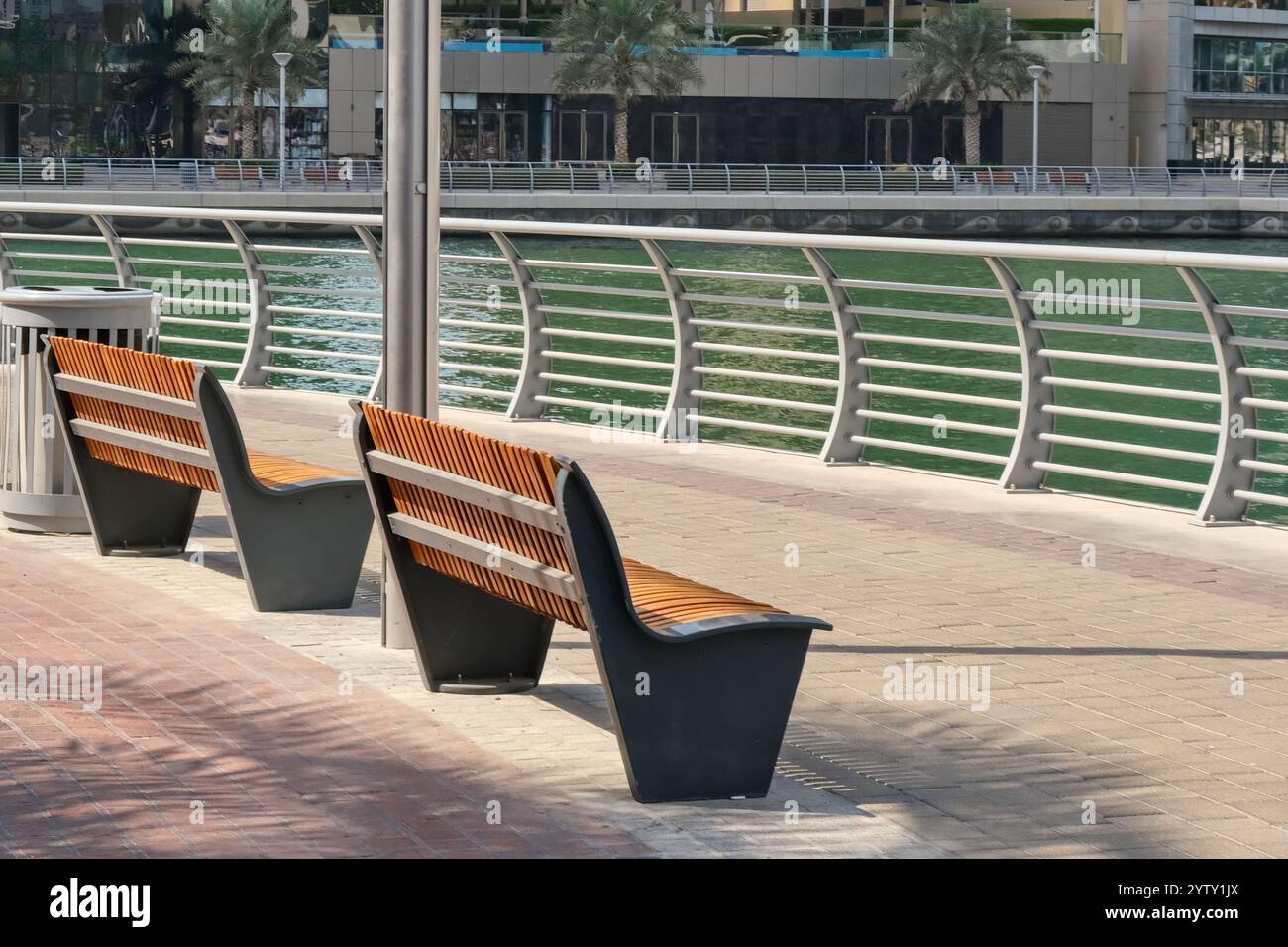 Recreation area with empty contemporary wooden benches along waterfront ...
