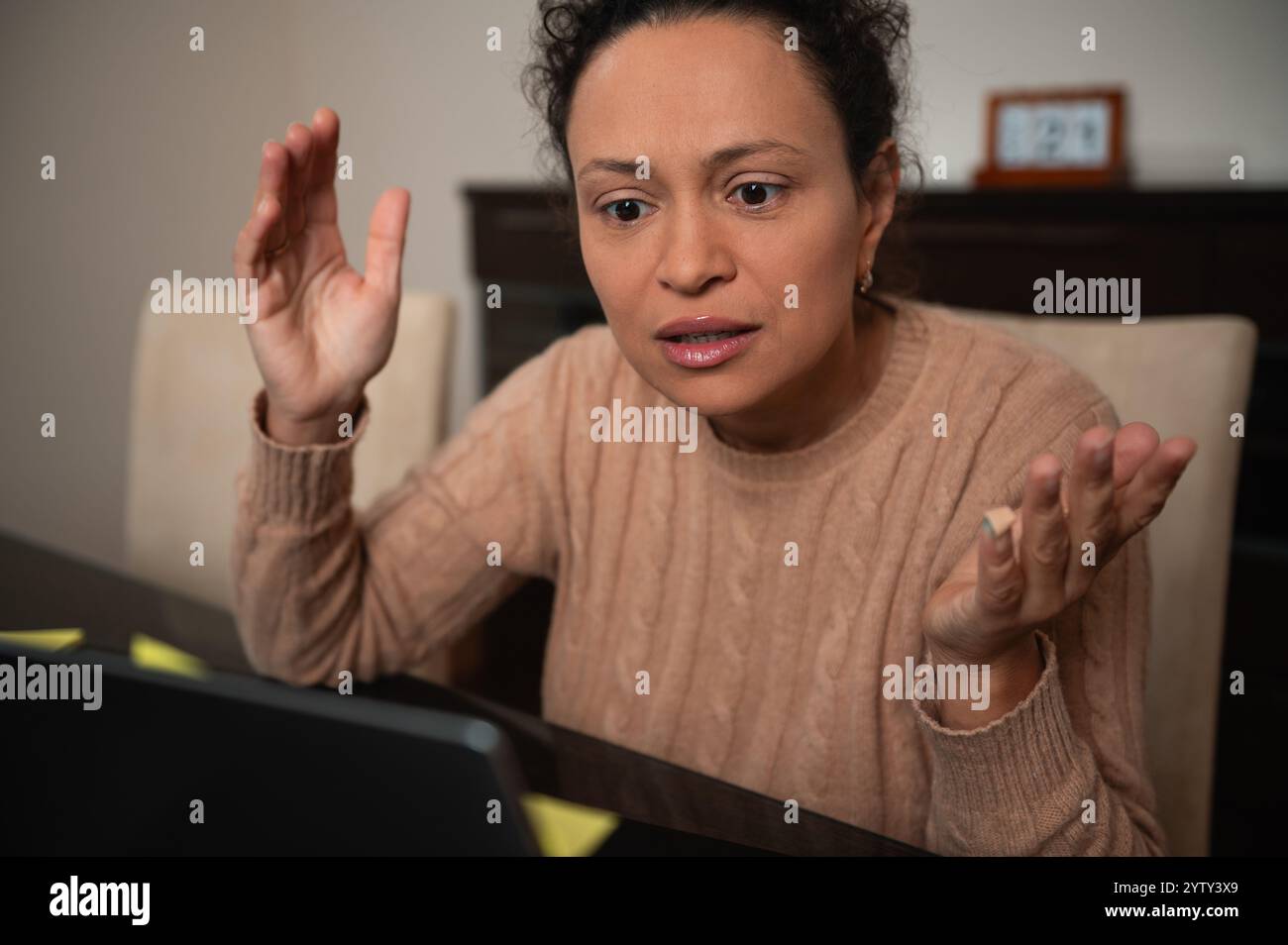 A woman shows a confused expression while communicating online. She ...