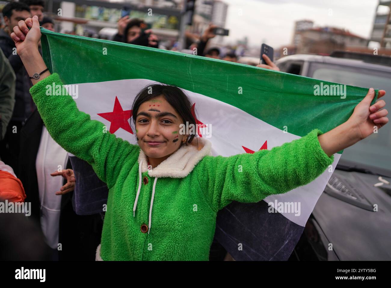 Ankara, Turkey. 08th Dec, 2024. A Syrian girl unfurls the new Syrian ...
