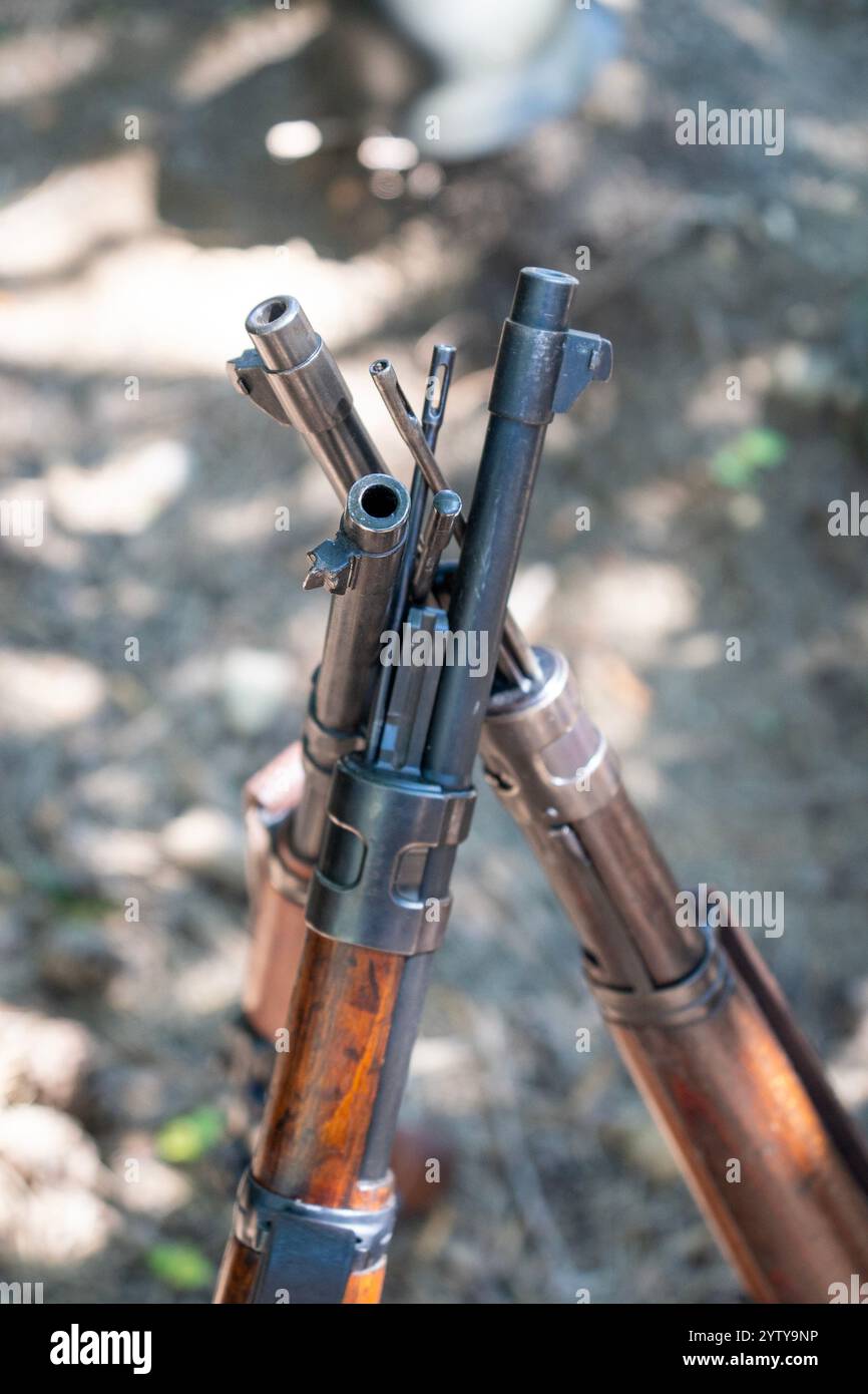 WWII rifles propped up against each other in a military camp Stock ...
