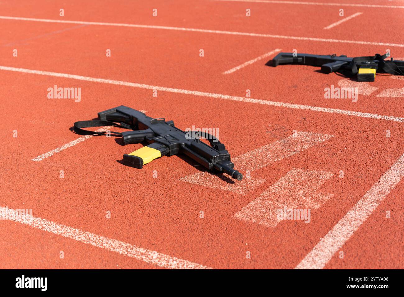 Practice weapons on the starting line of an orange running track Stock ...