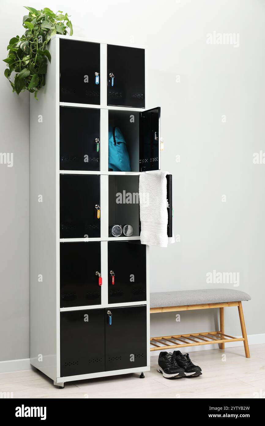 Lockers with personal belongings and bench in changing room at gym ...