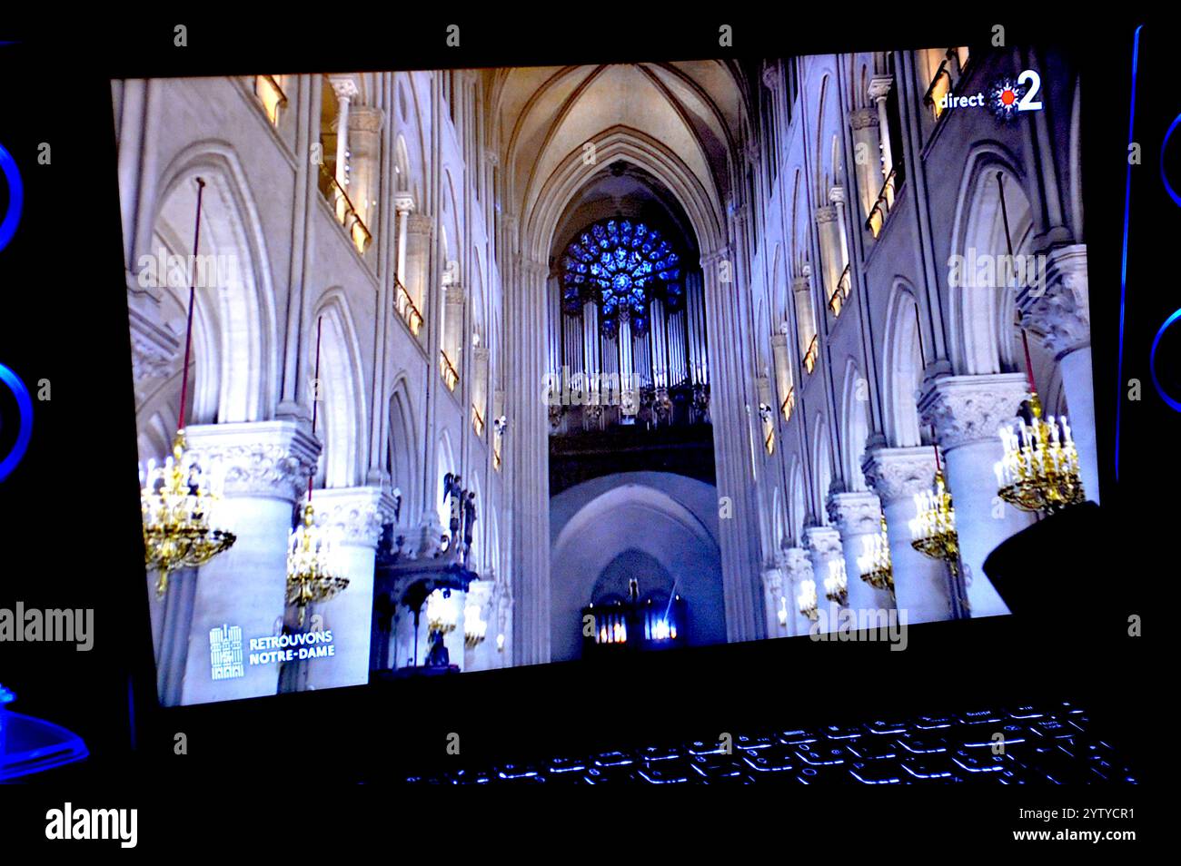 A man watches the reopening ceremony of Notre Dame Cathedral in Paris on his computer. Reopening ...