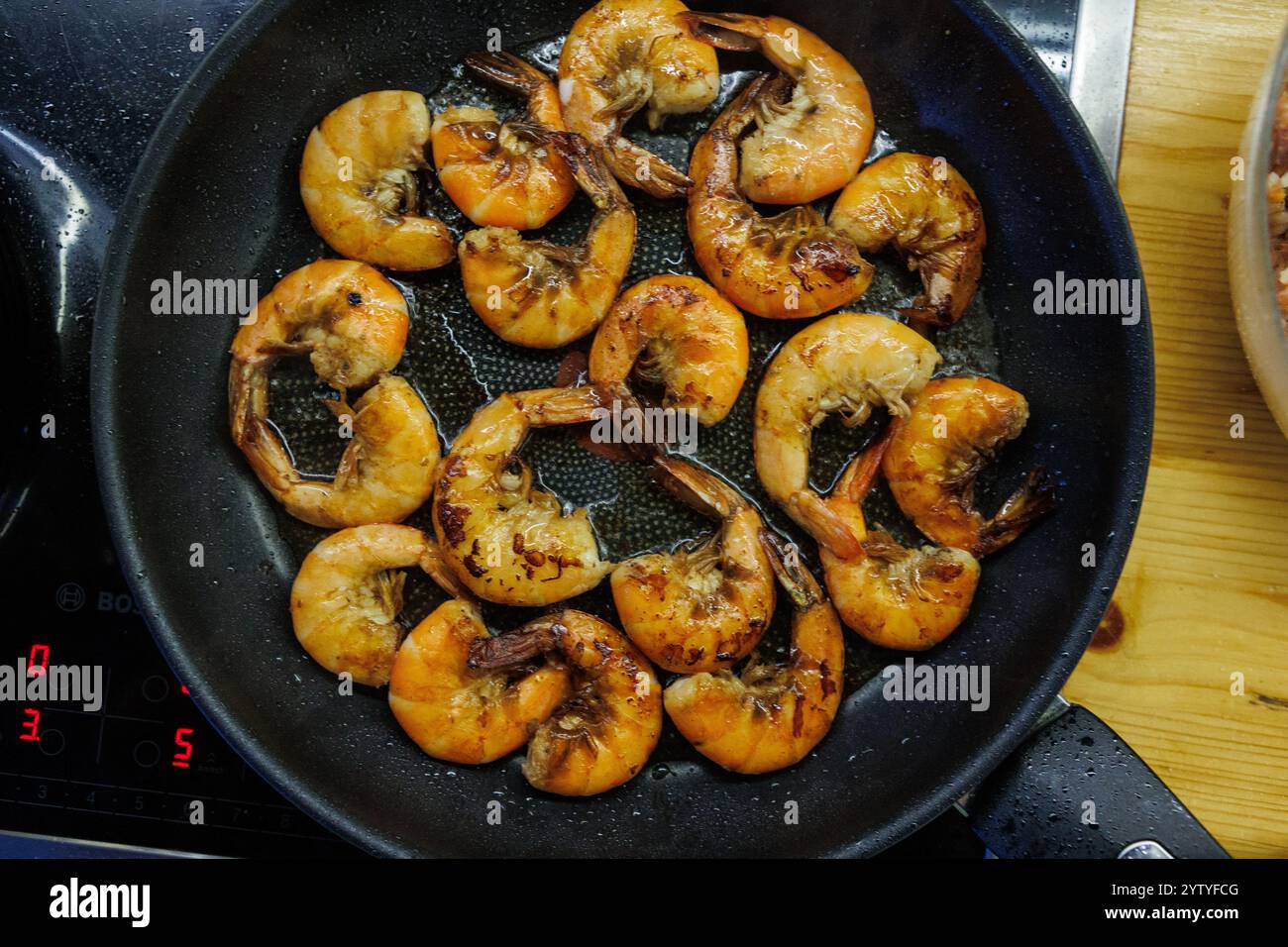 Golden pan-fried shrimp sizzling in a skillet, showcasing their rich ...