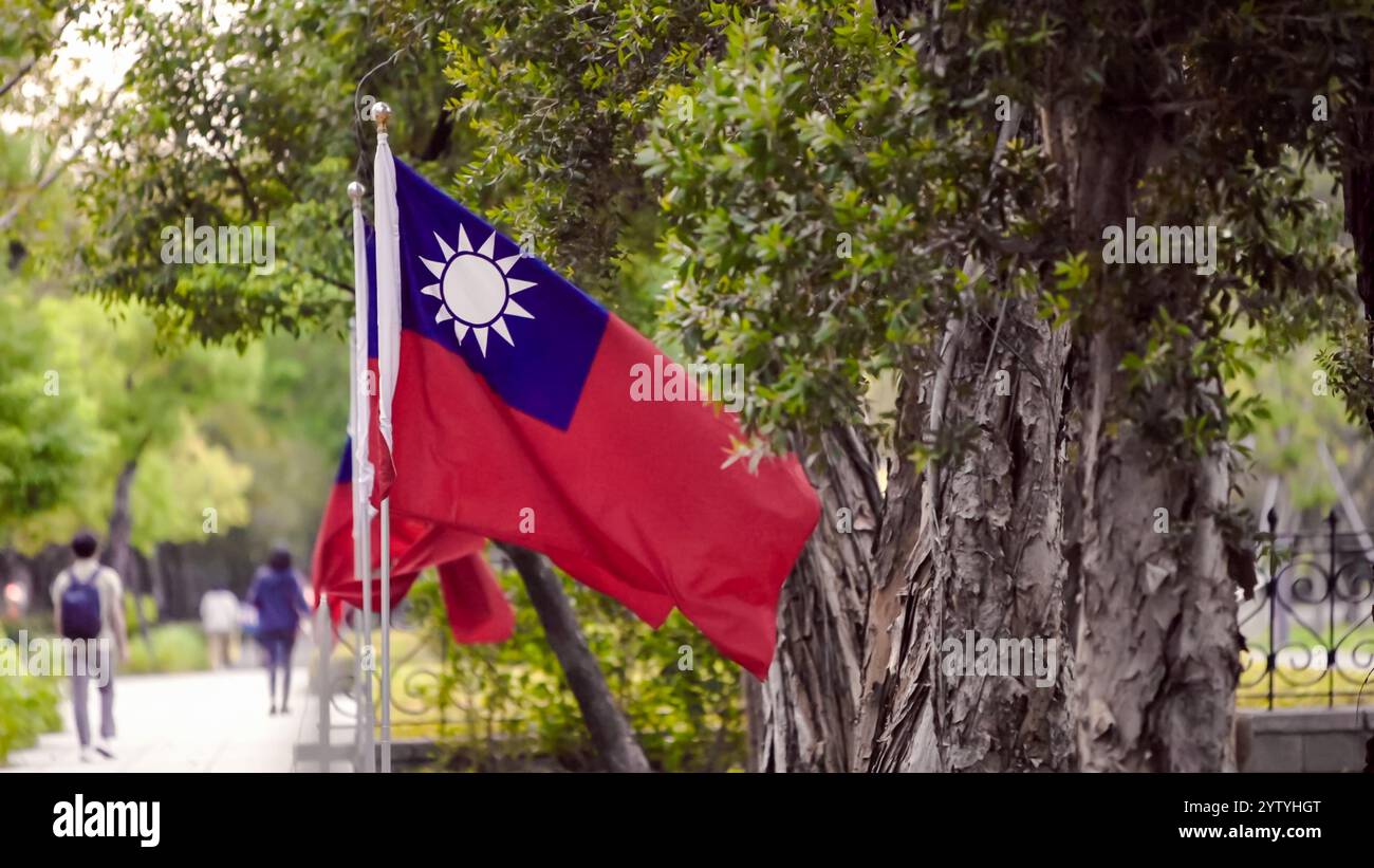 Taiwan flag waving amidst green trees in a park, evoking a sense of ...
