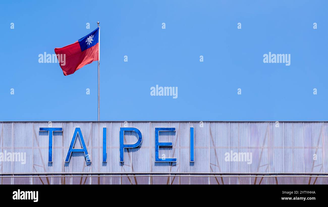 The national flag of Taiwan waving proudly against a clear blue sky in ...