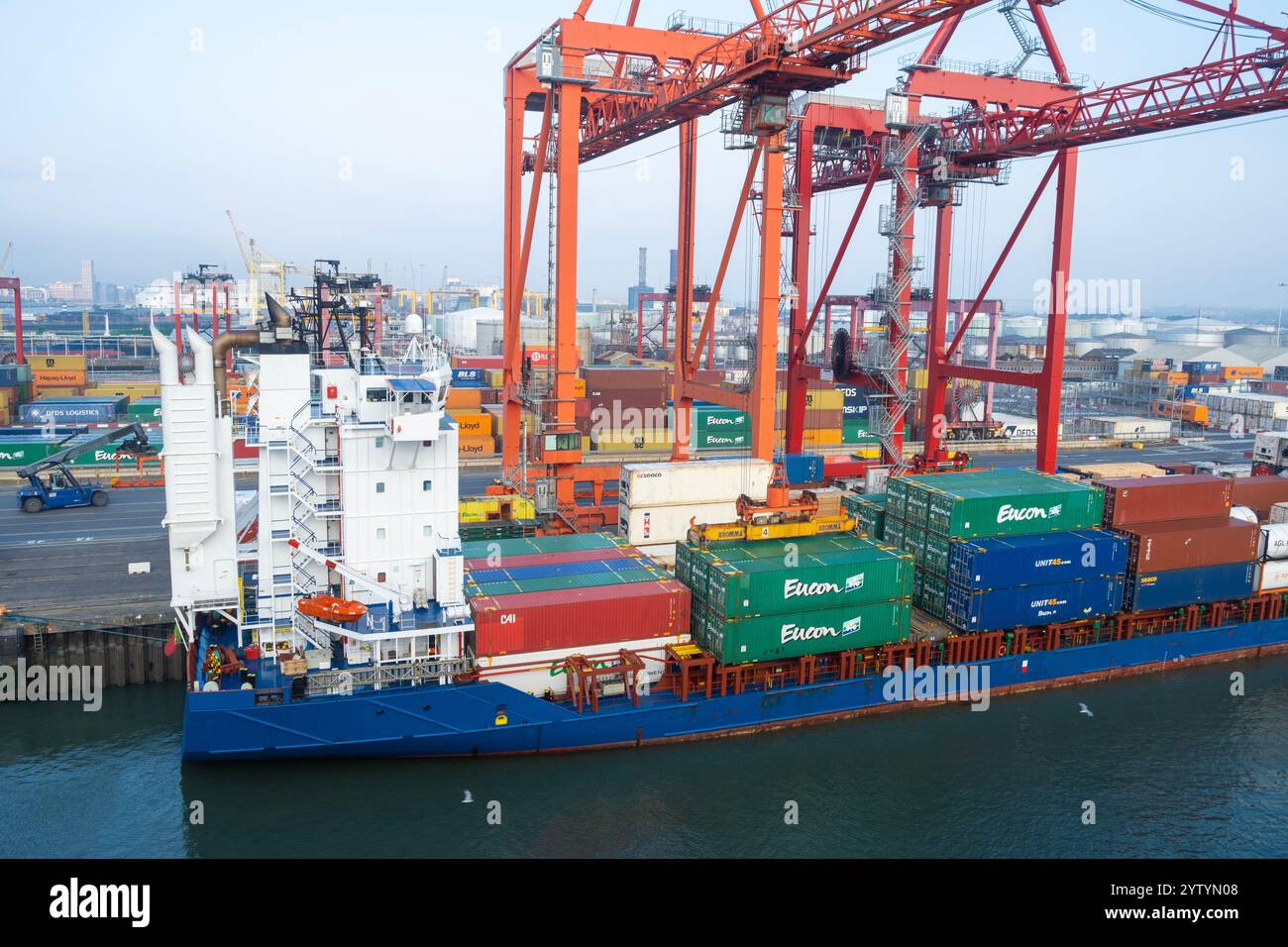 Container terminal gantry crane lifting cargo container in sea port hi ...