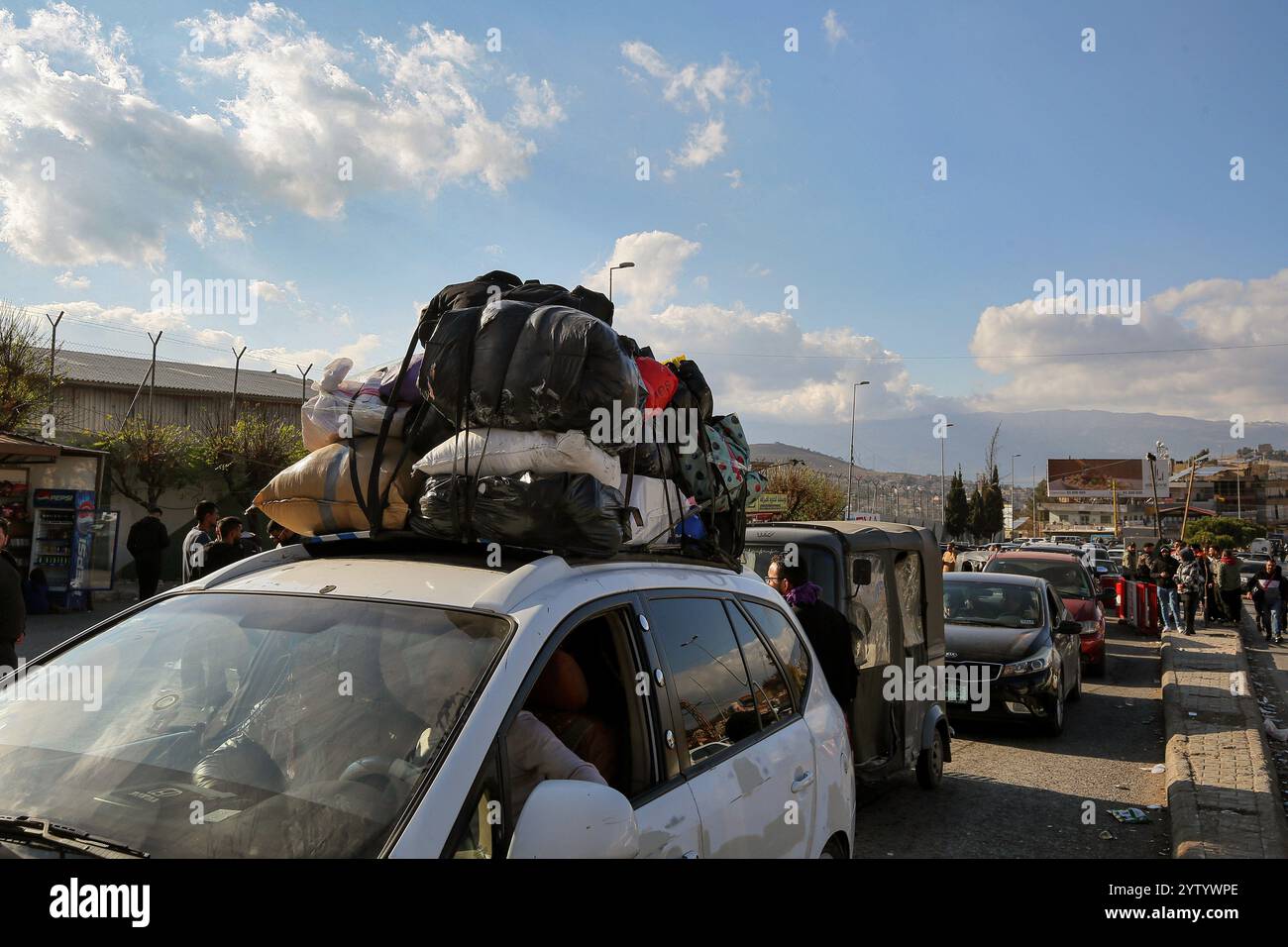 08 December 2024, Lebanon, Masnaa: Line of cars loaded with Syrian ...