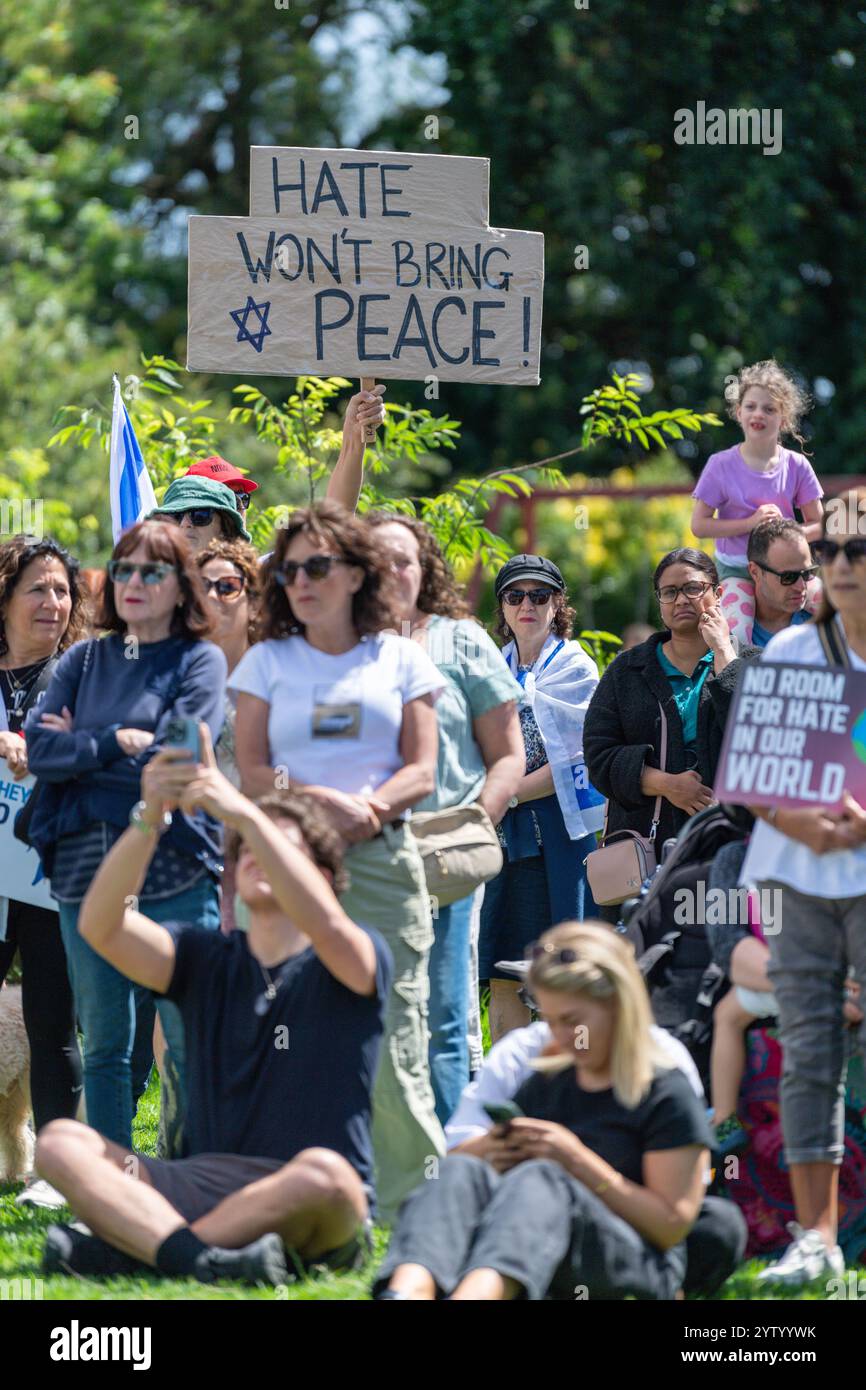 A person holds a sign saying "Hate won't bring peace as protesters hold ...
