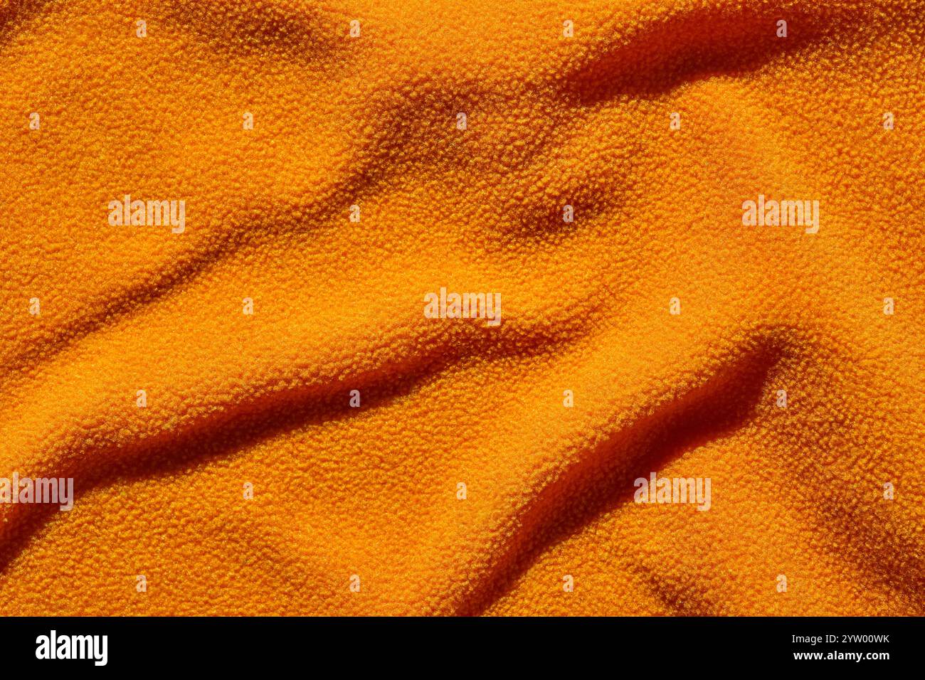 Soft orange fabric texture with dynamic folds and shadow play creating ...