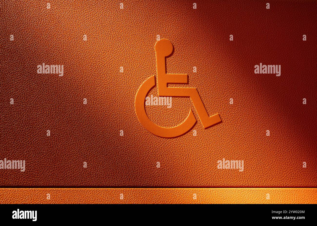 A close up of a wheelchair symbol on an orange surface. The orange ...