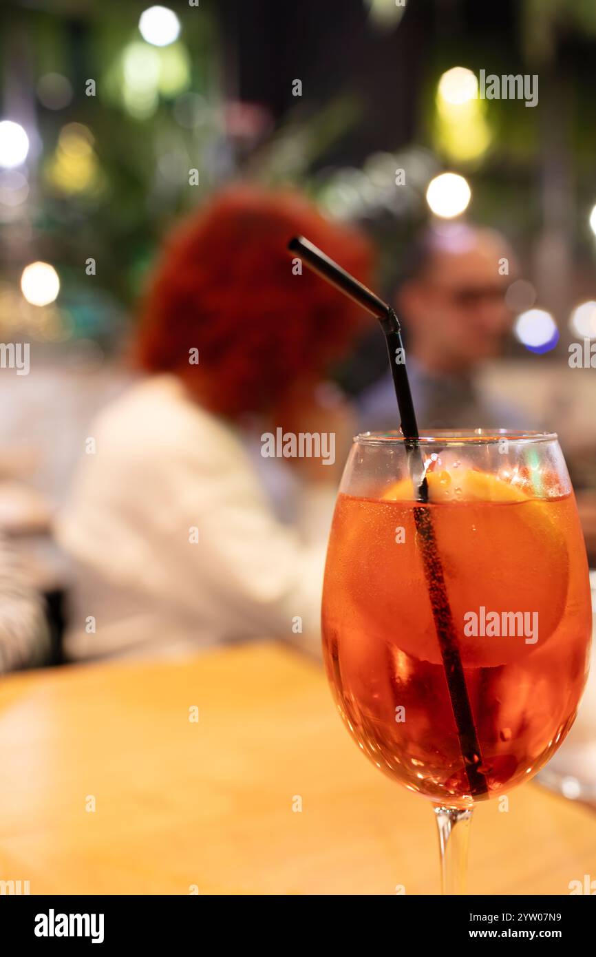cup of aperol cocktail with friends, red hair woman and green ...