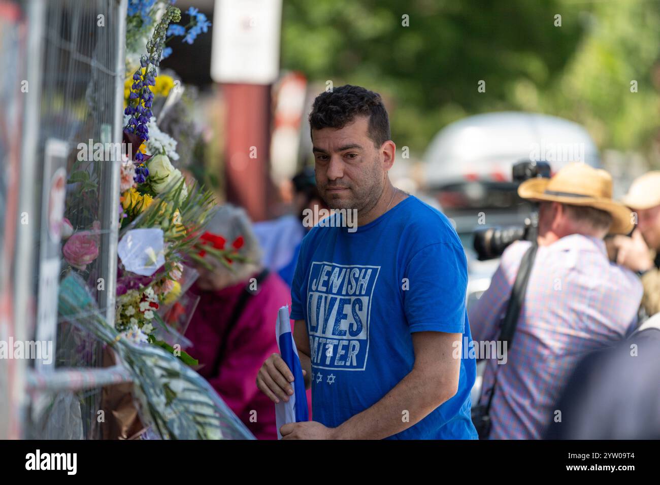 A man wearing a "Jewish Lives Matter" t-shirt stops after placing ...