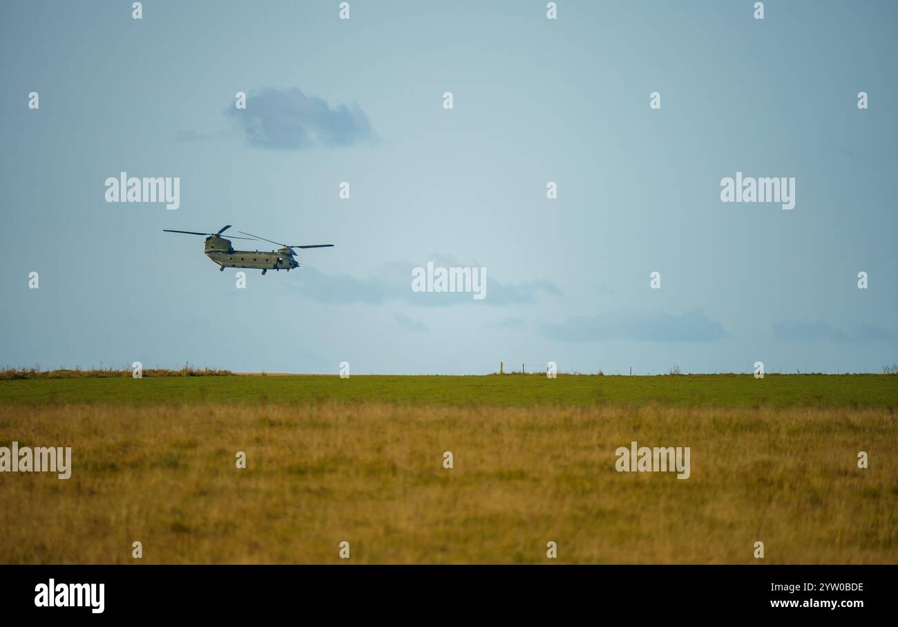 RAF Chinook tandem-rotor helicopter flying fast and low on a military ...