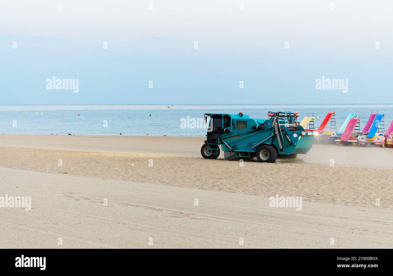 A beach cleaning machine clears debris from the sand, ensuring a ...