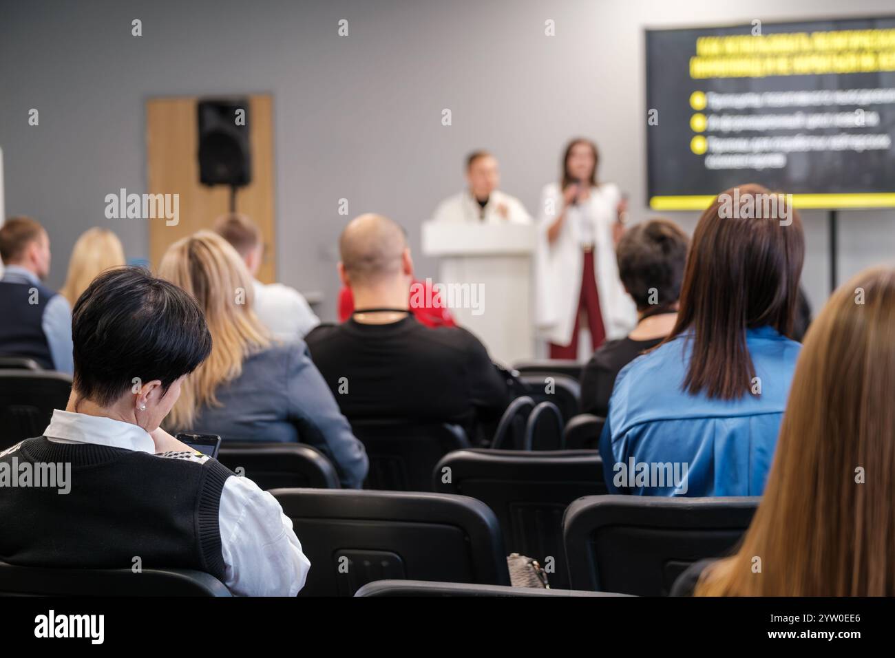 Group of people attending conference presentation in meeting hall with ...