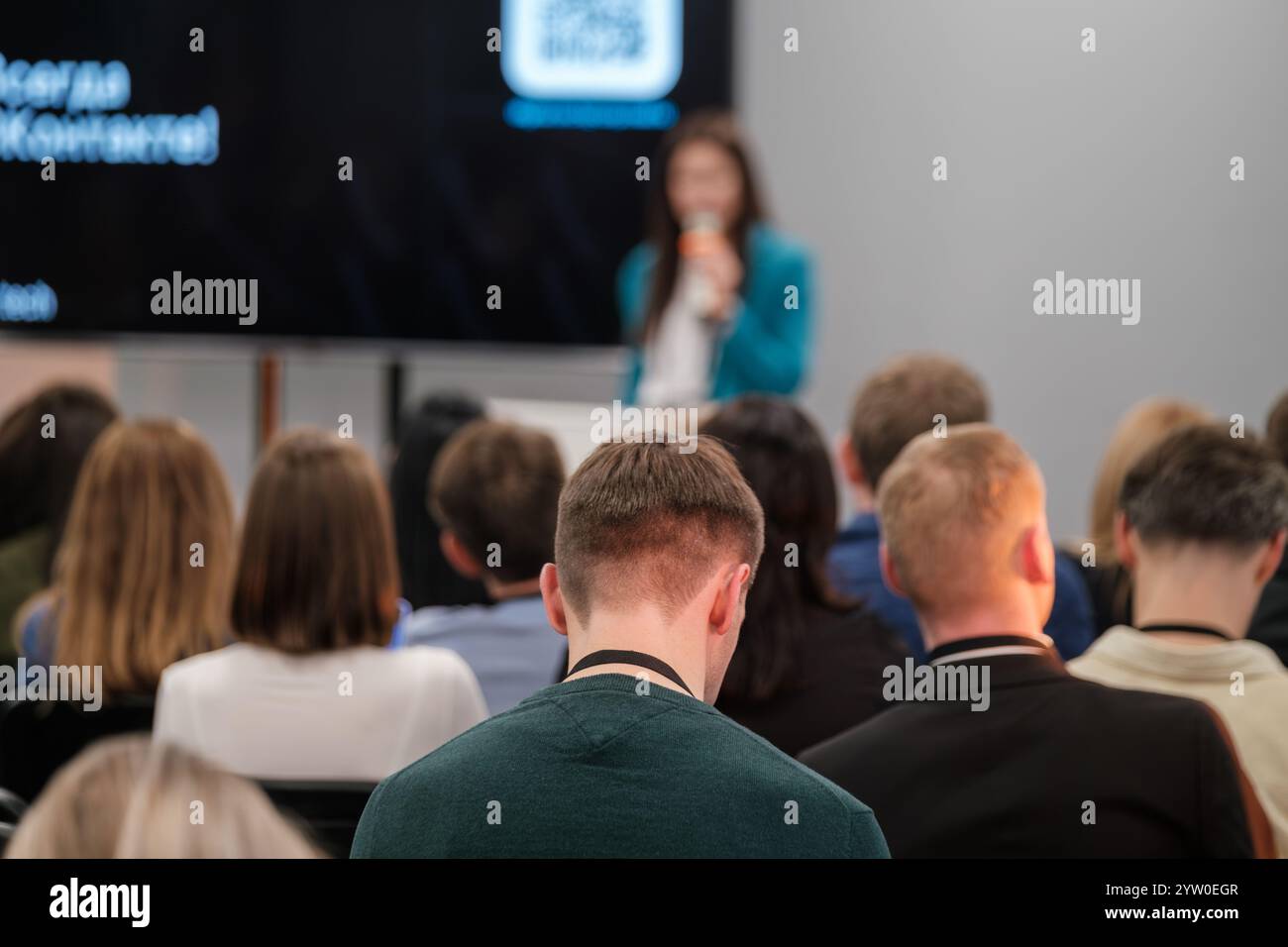 Attendees engaged in business conference presentation. Focus on ...