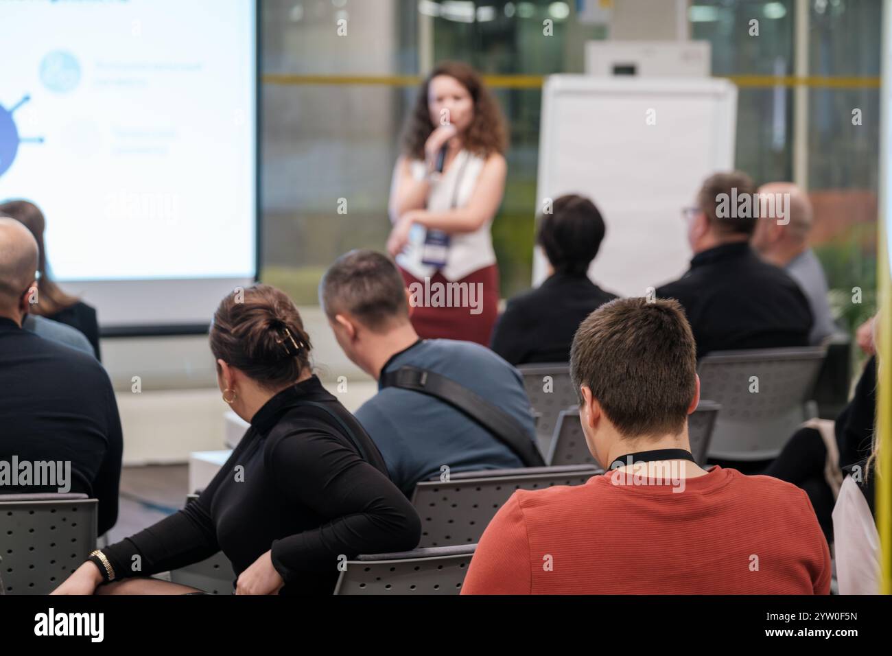 Diverse group participating in a business seminar, focusing on speaker ...