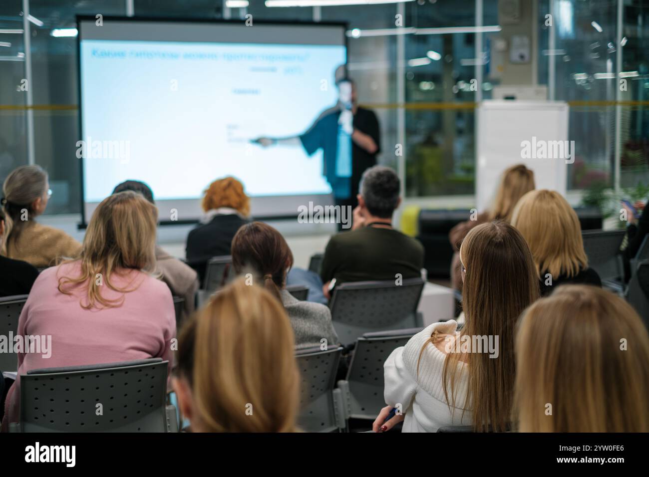 Diverse audience attentively listening to a business presentation in a ...