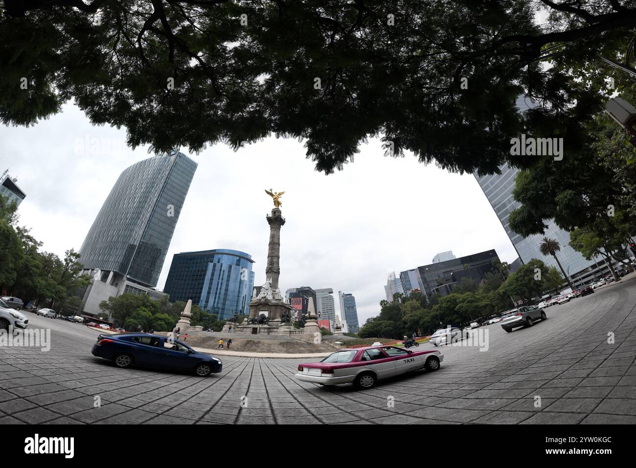 A vibrant intersection in Mexico City features a tall statue at its ...