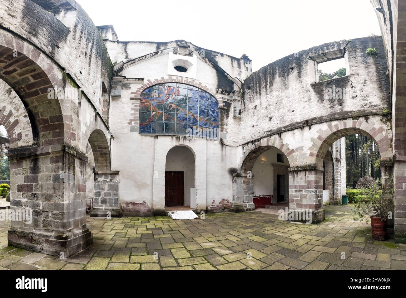This courtyard features arched stone structures and a large stained ...