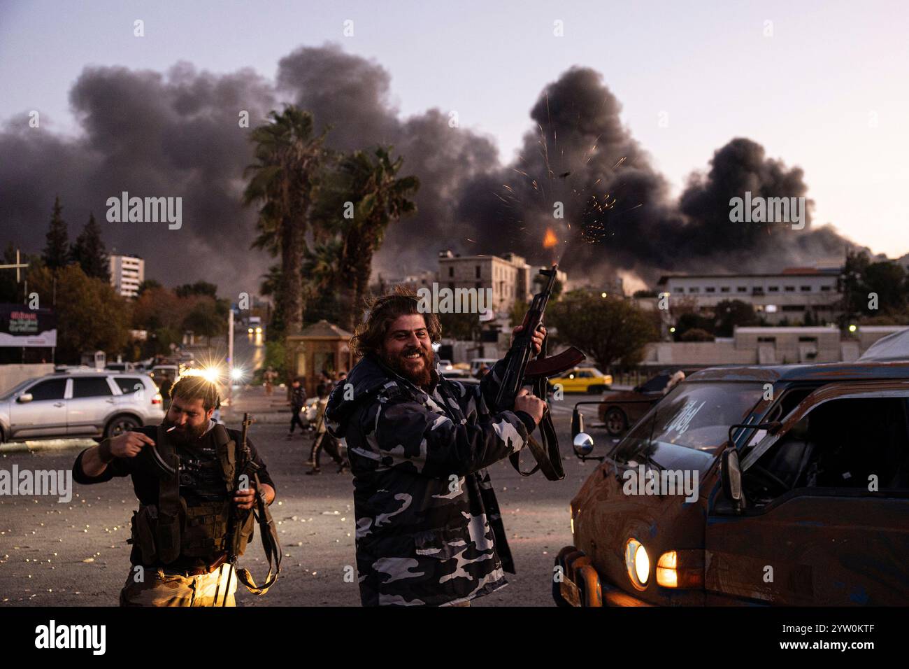 People shoot in the air as they celebrate the fall of the Syrian ...