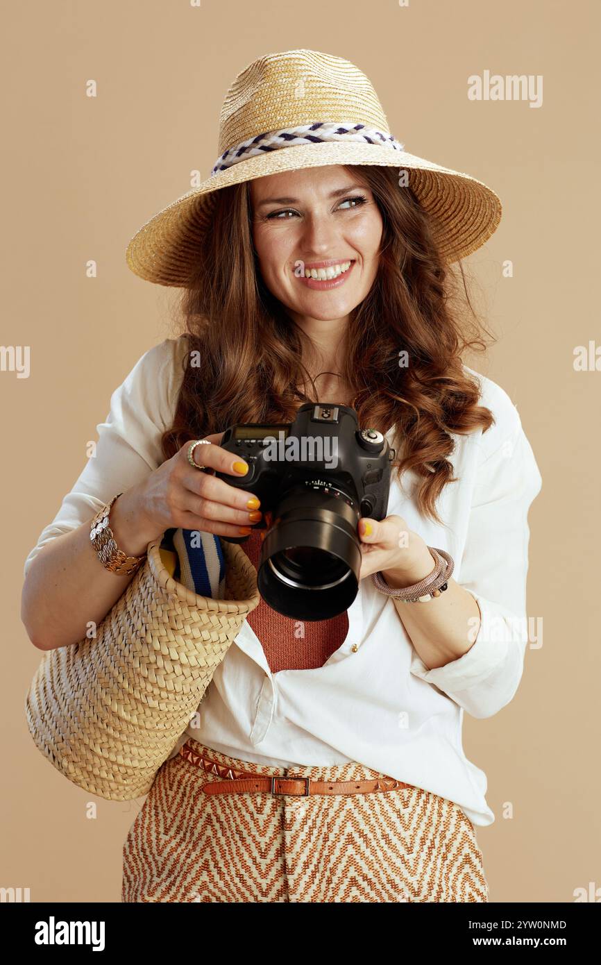 Beach vacation. smiling trendy middle aged woman in white blouse and shorts isolated on beige ...