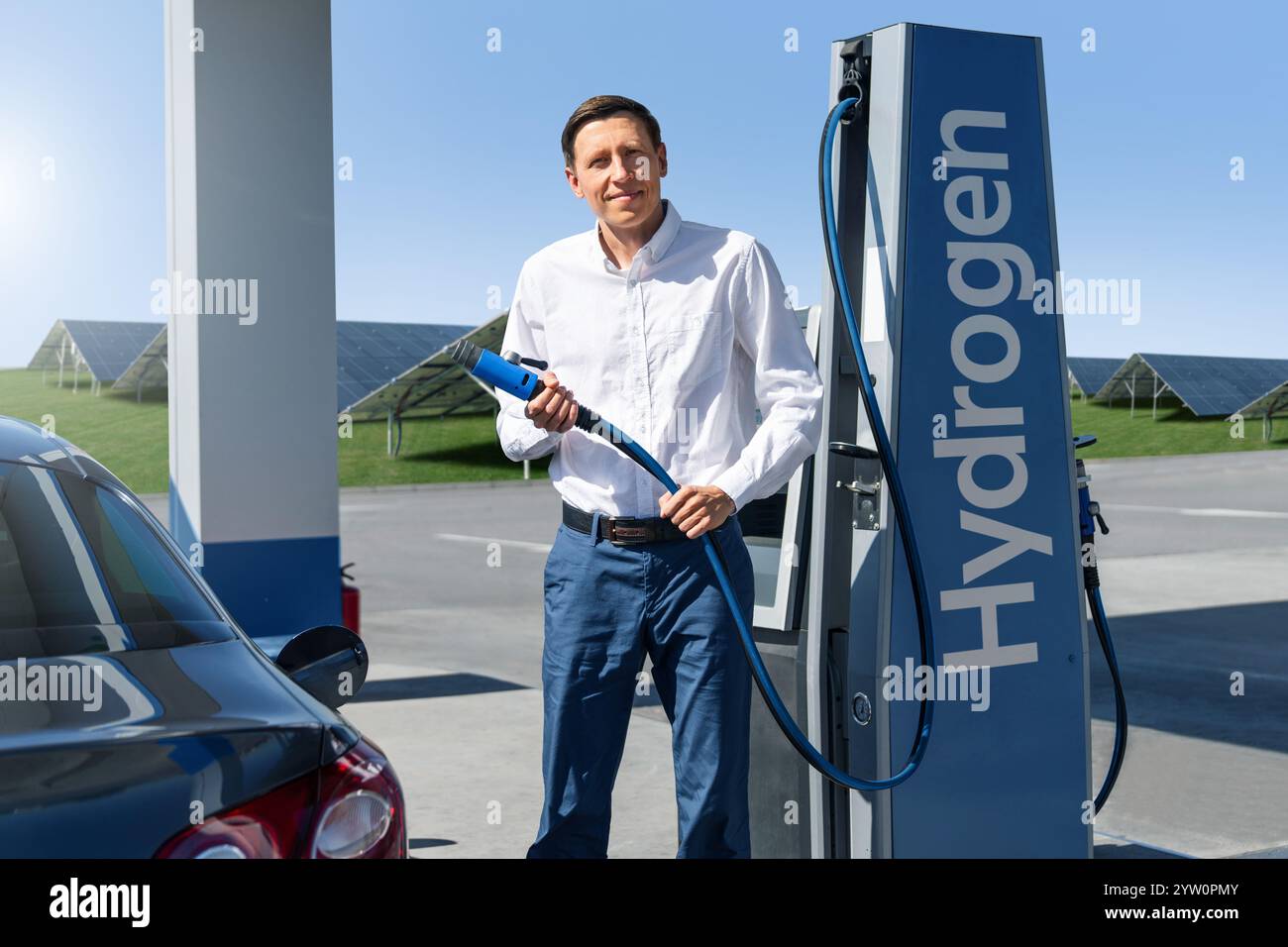 Man holds a hydrogen fueling nozzle on a hydrogen filling station ...