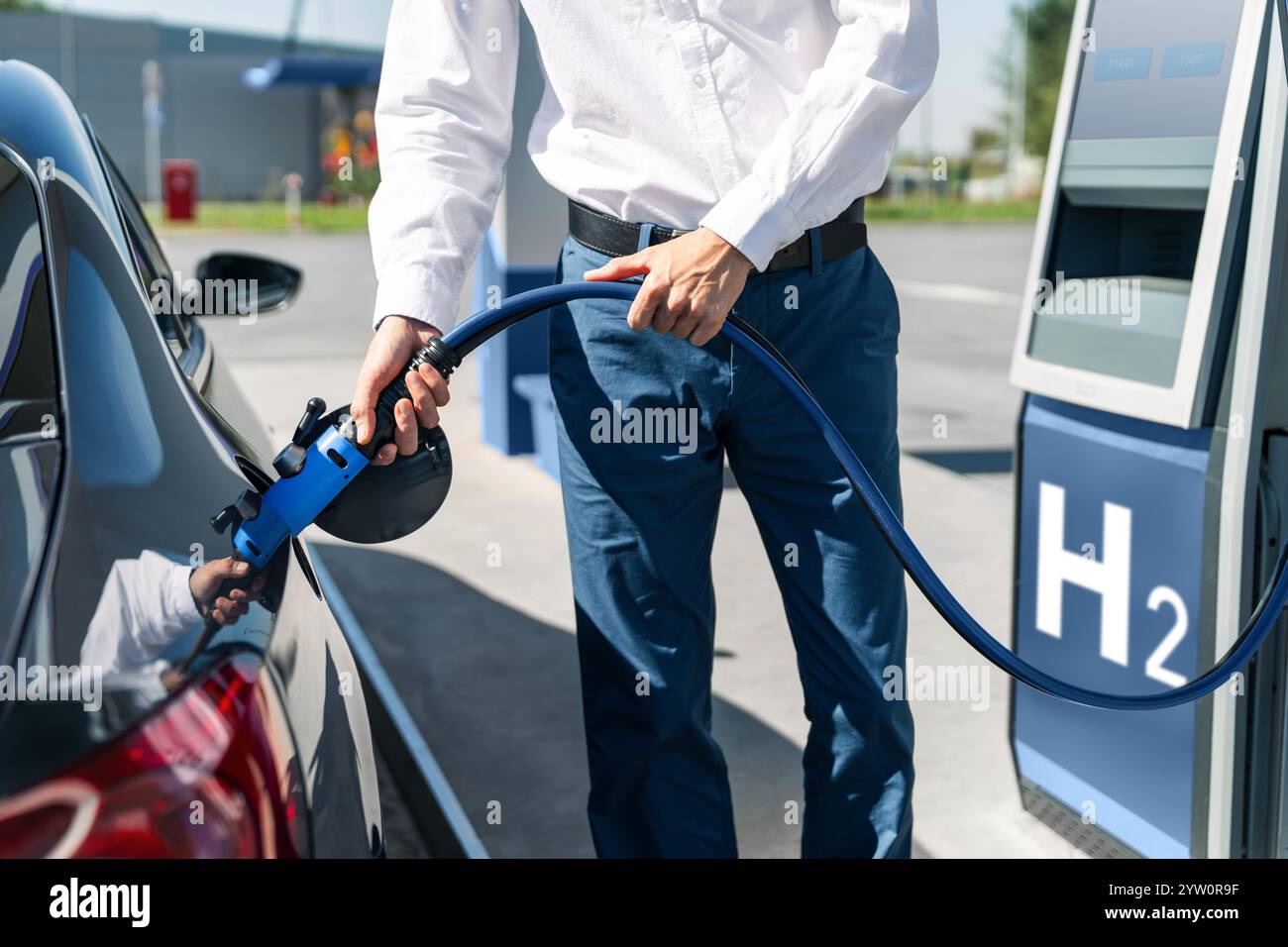 Man holds a hydrogen fueling nozzle on a hydrogen filling station ...