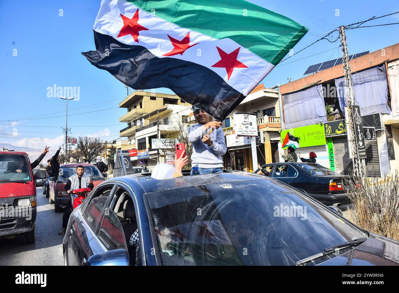Beirut, Lebanon. 08th Dec, 2024. Syrians cheer and wave national flags ...