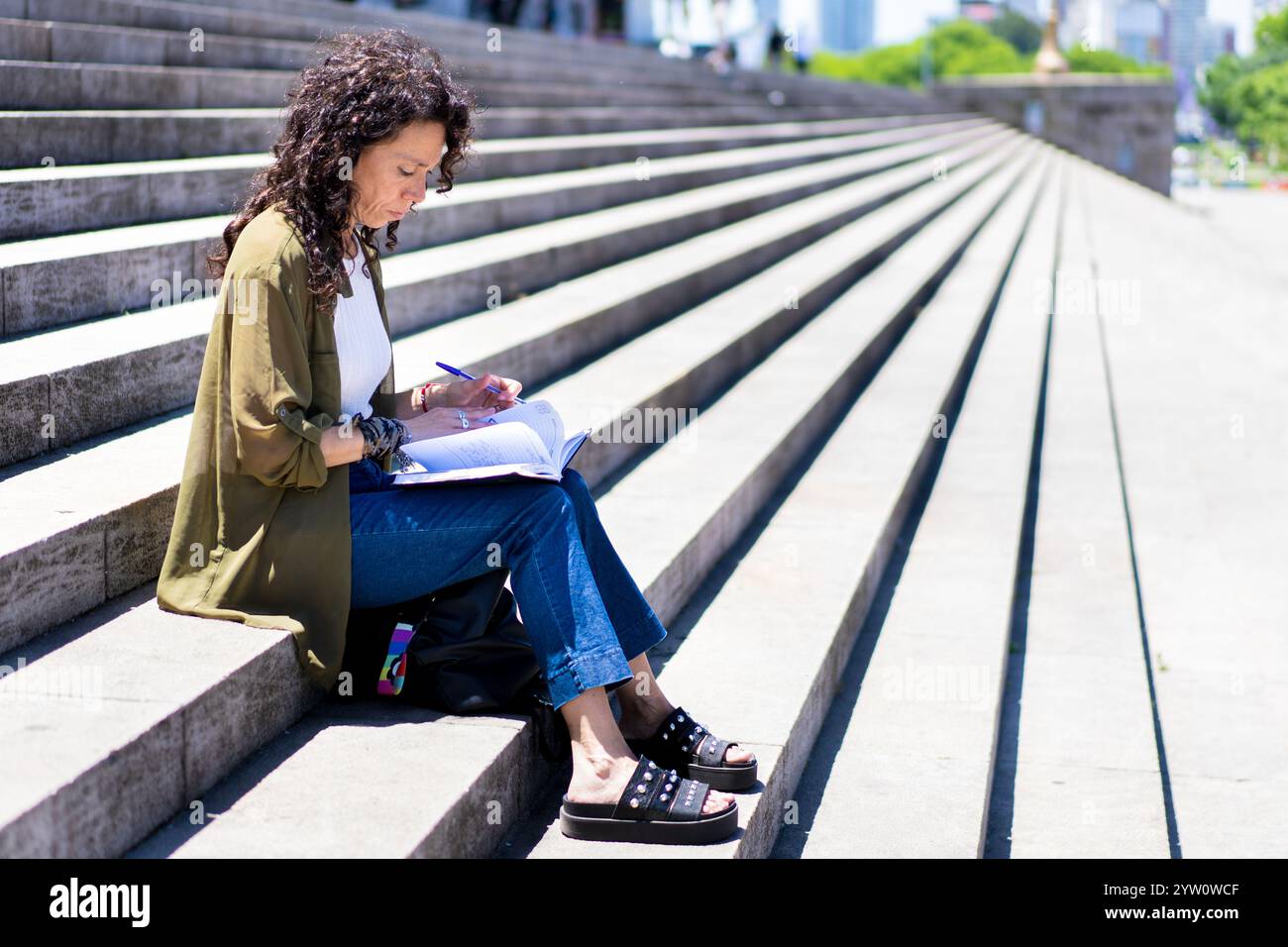Mid-adult Student sketching in her notebook on university steps Stock ...