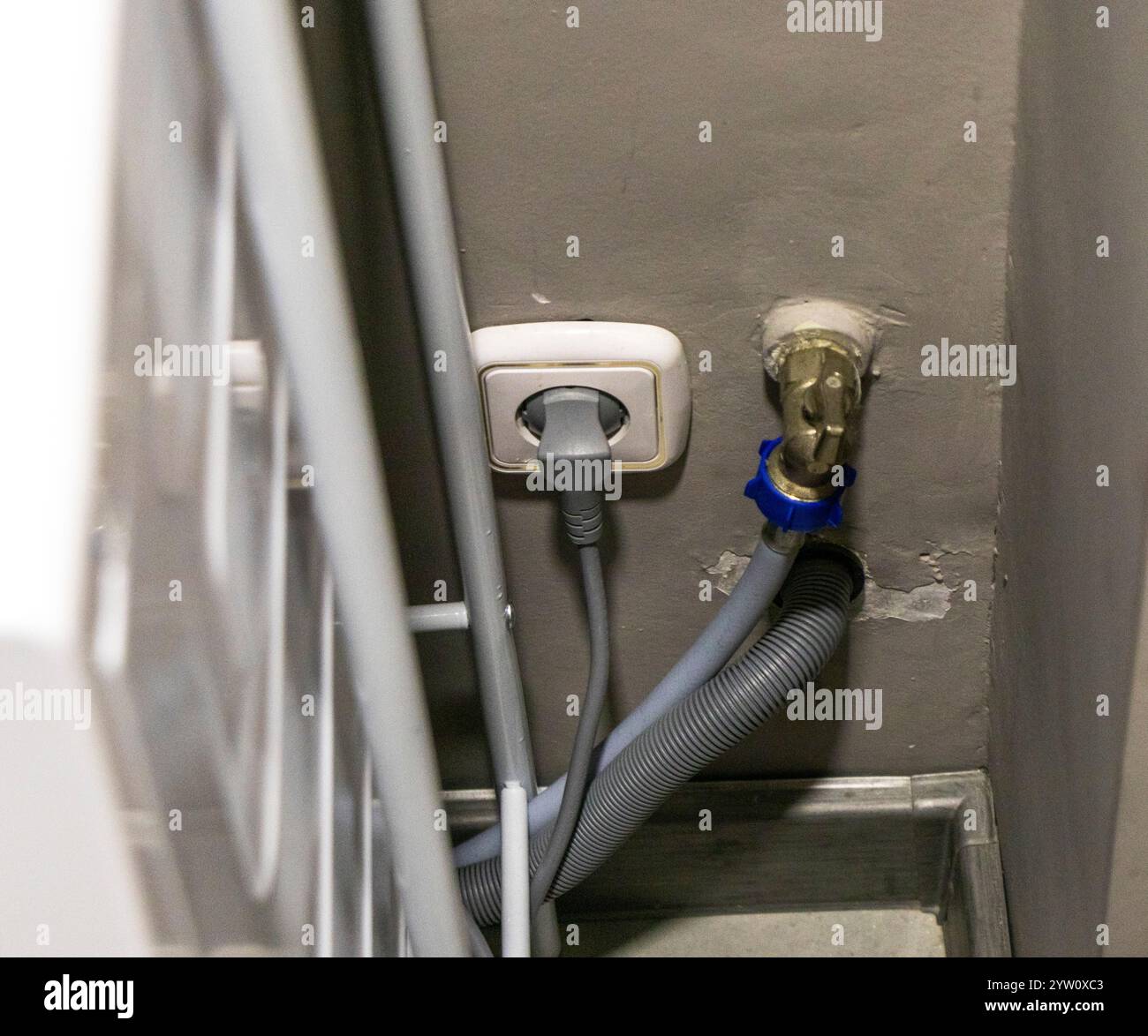 Electrical and plumbing washing machine connections Stock Photo - Alamy