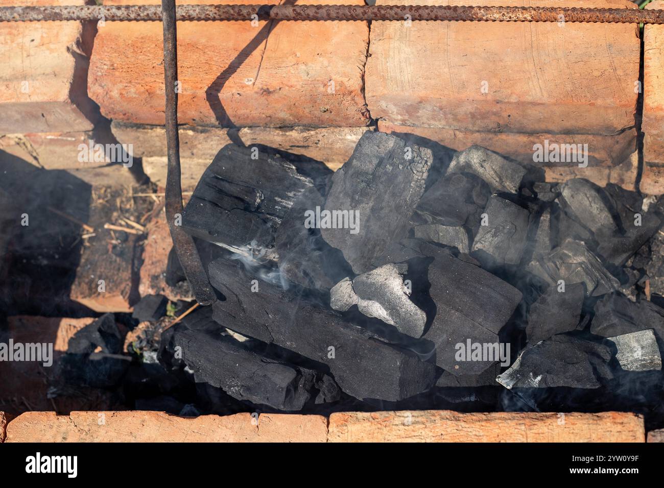 Burning charcoal in a barbecue. Fuel for cooking food at a campsite on ...