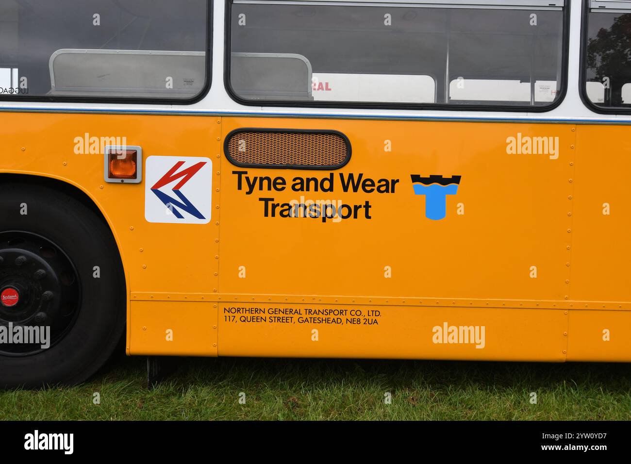 Side view of a vintage yellow bus bearing the logos of Tyne and Wear ...