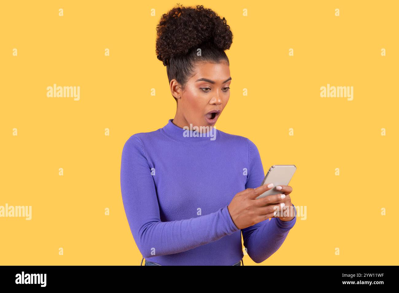 Young Hispanic woman reacts with surprise while using her smartphone ...