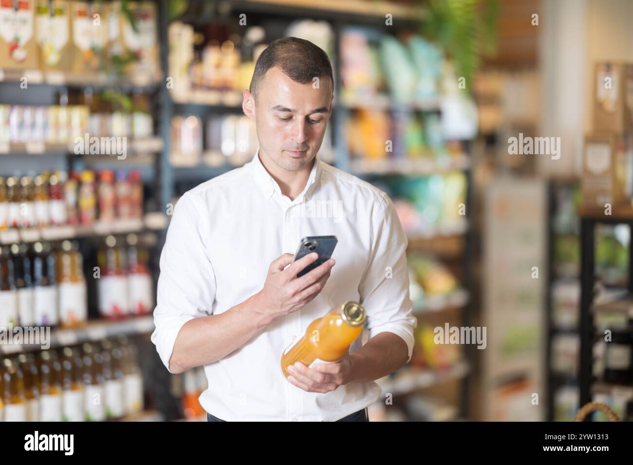 Man in supermarket scan QR code on bottle of drink Stock Photo - Alamy